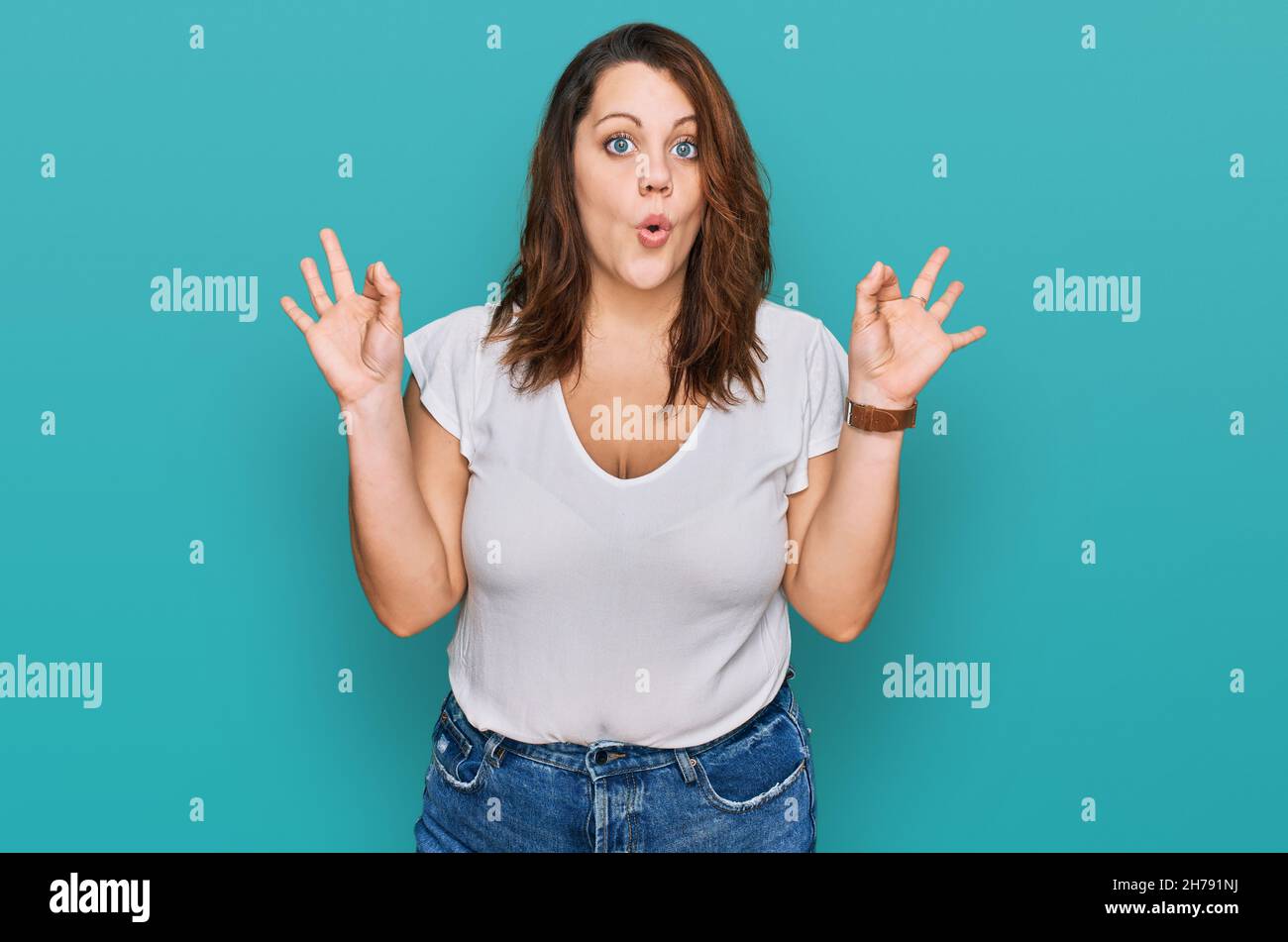 Young Plus Size Woman Wearing Casual White T Shirt Looking Surprised