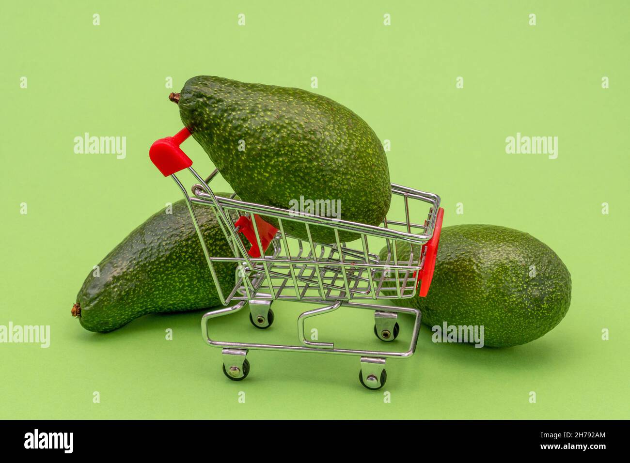 Avocado fruits and shopping grocery cart. Shopping at the supermarket ...
