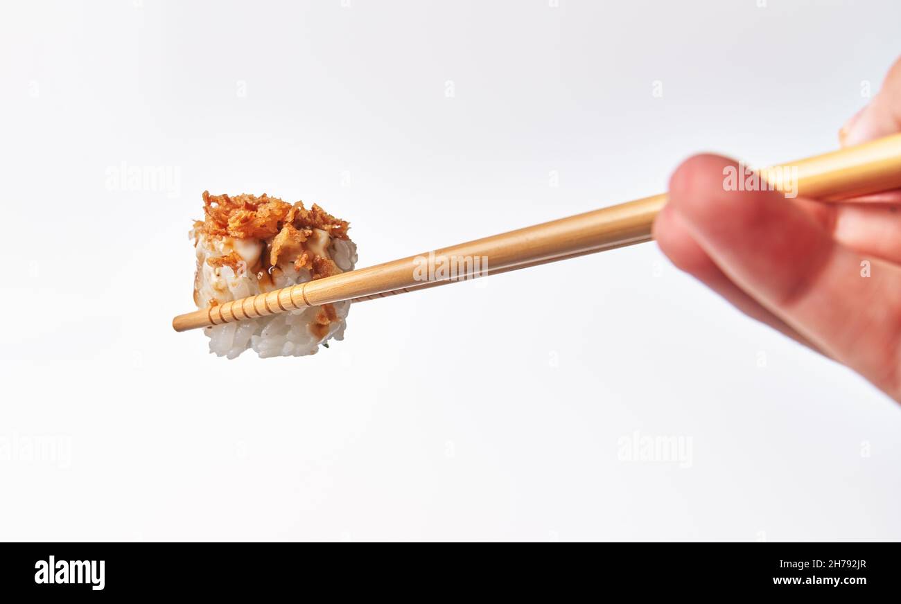 Chopsticks holding single uramaki sushi isolated on white background ...