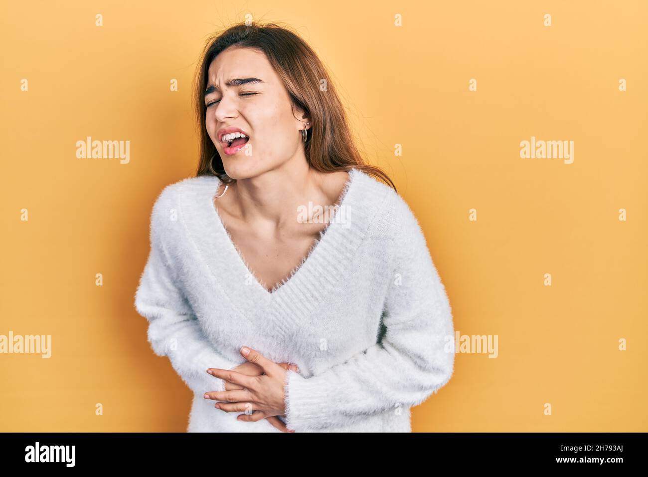Young caucasian girl wearing casual clothes with hand on stomach ...