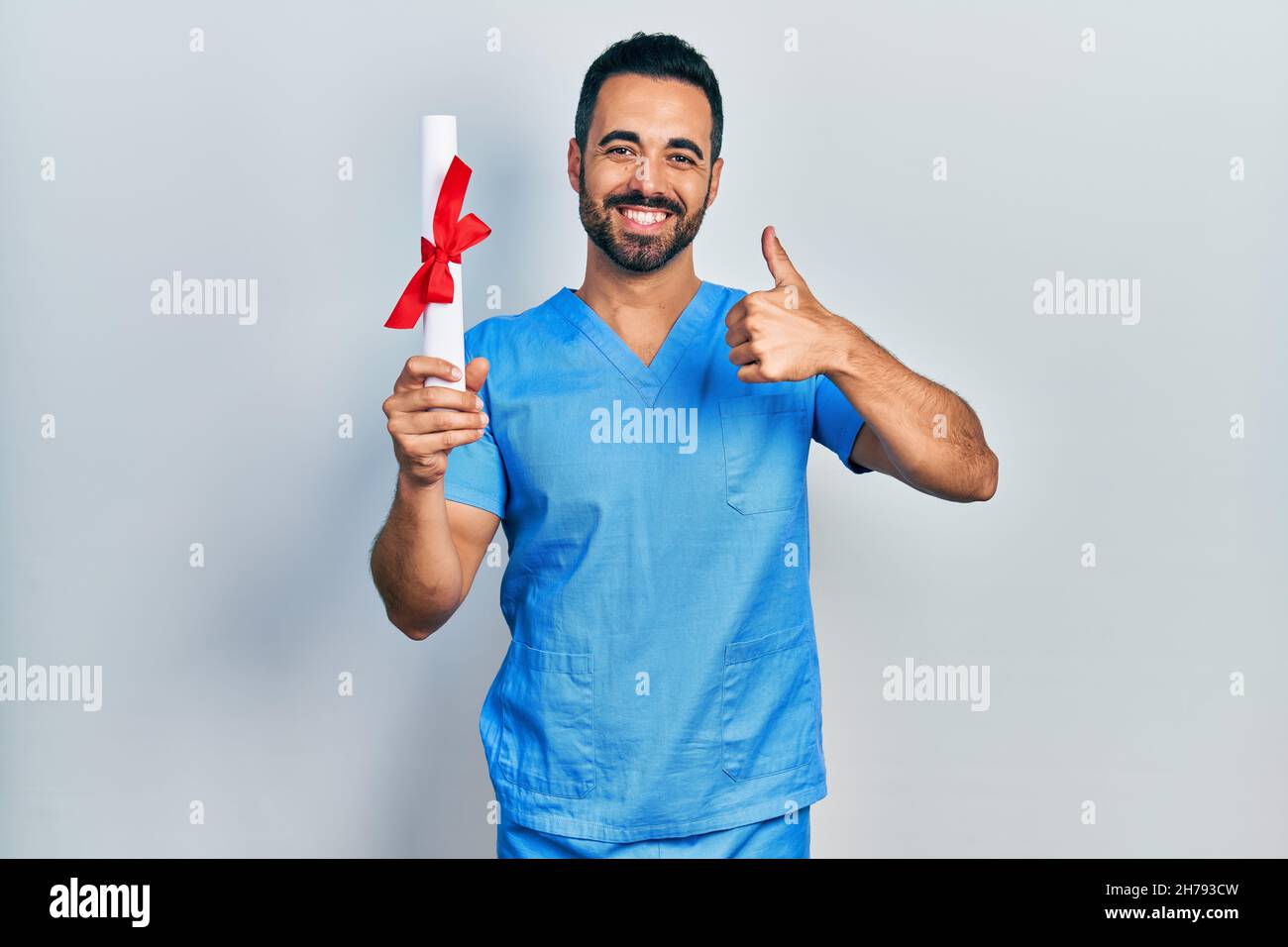 Handsome hispanic man with beard wearing blue male nurse uniform ...