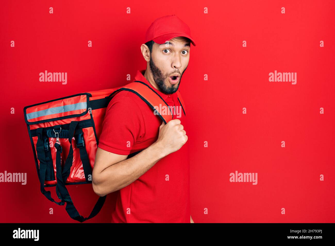 Hispanic man with beard wearing delivery package backpack scared and ...