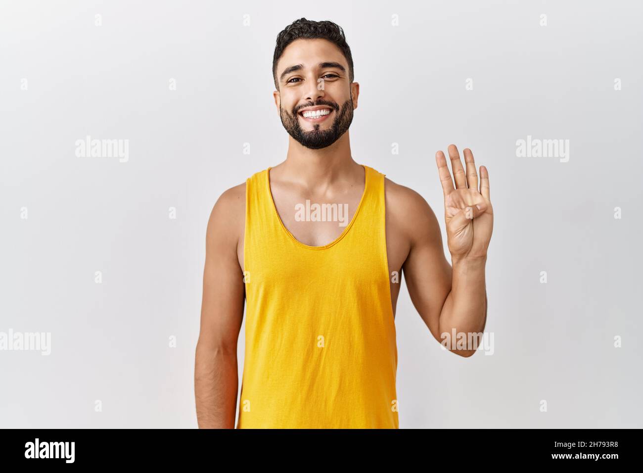 Young handsome man with beard standing over isolated background showing ...