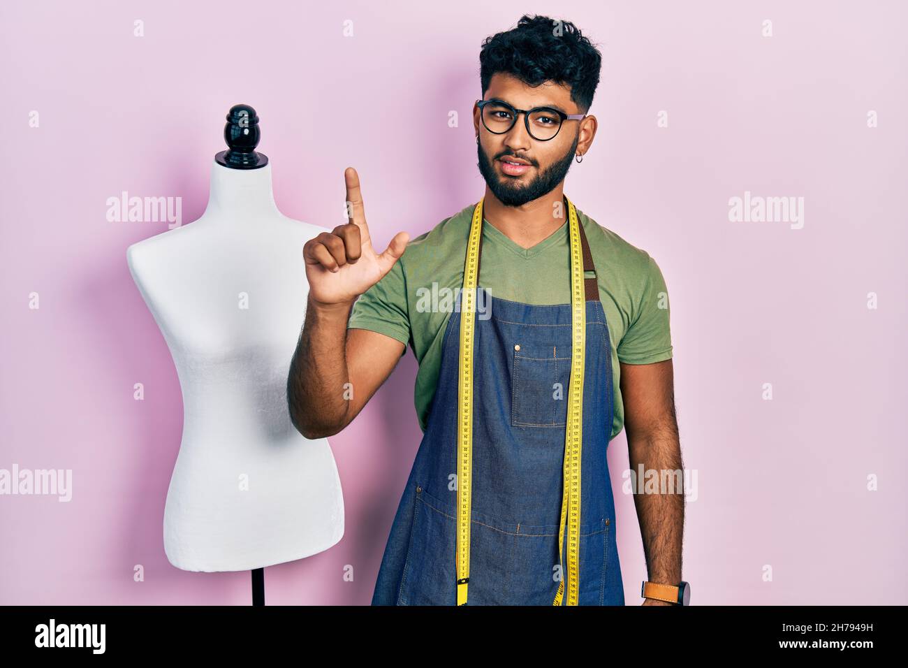 Arab man with beard dressmaker designer wearing atelier apron smiling ...