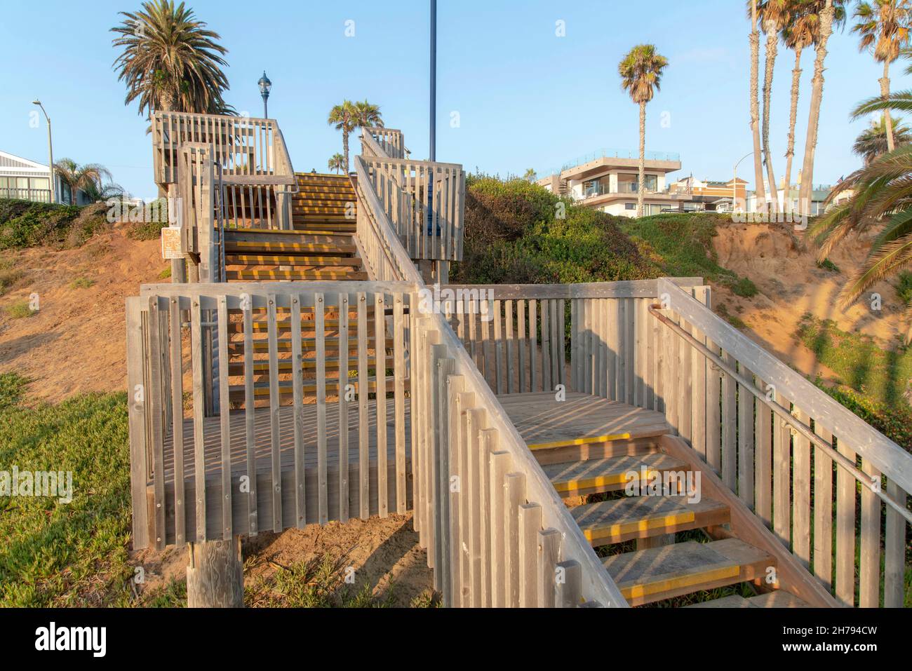 Wooden outdoor stairs near the grassy slope with trees at Oceanside ...