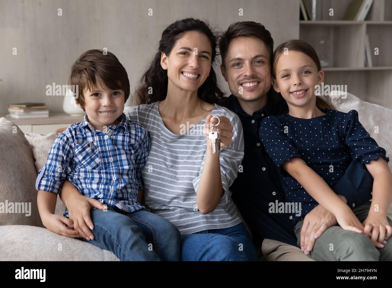 Happy family with children holding keys from new house Stock Photo - Alamy