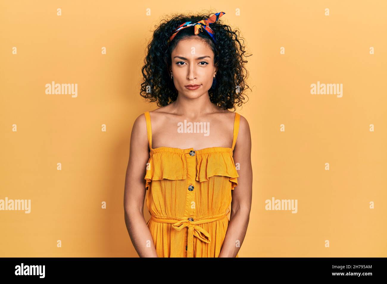 Young latin girl wearing summer dress skeptic and nervous, frowning ...