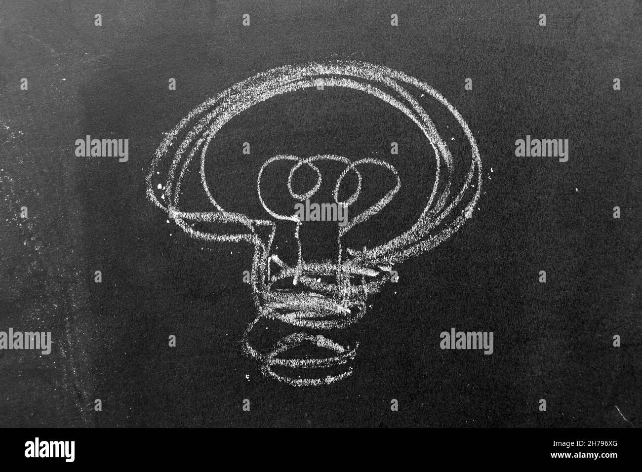 White color chalk hand drawing in light bulb shape on blackboard or ...