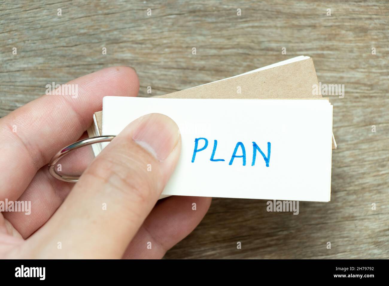 Man hold the flash card with handwriting word plan on wood background ...
