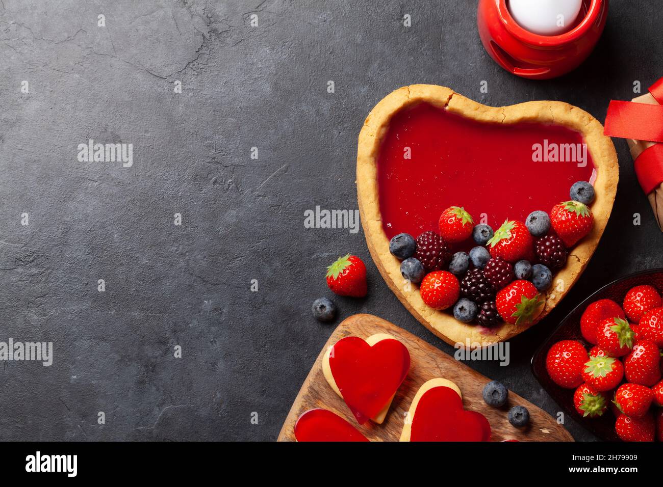 Heart shaped sweet cake with berries and gift box. Valentines Day ...