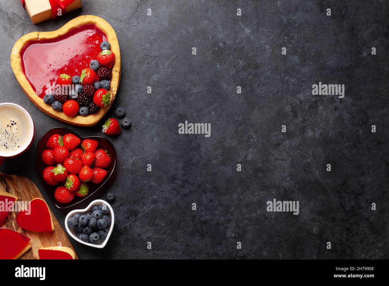 Heart shaped sweet cake with berries, coffee and gift box. Valentines ...