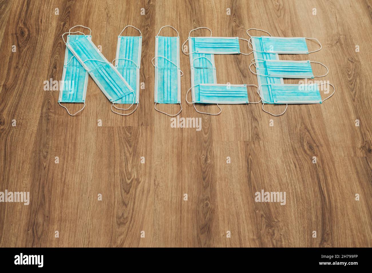 Capital Letters Nice Composed of Blue Medical Masks on a Brown ...