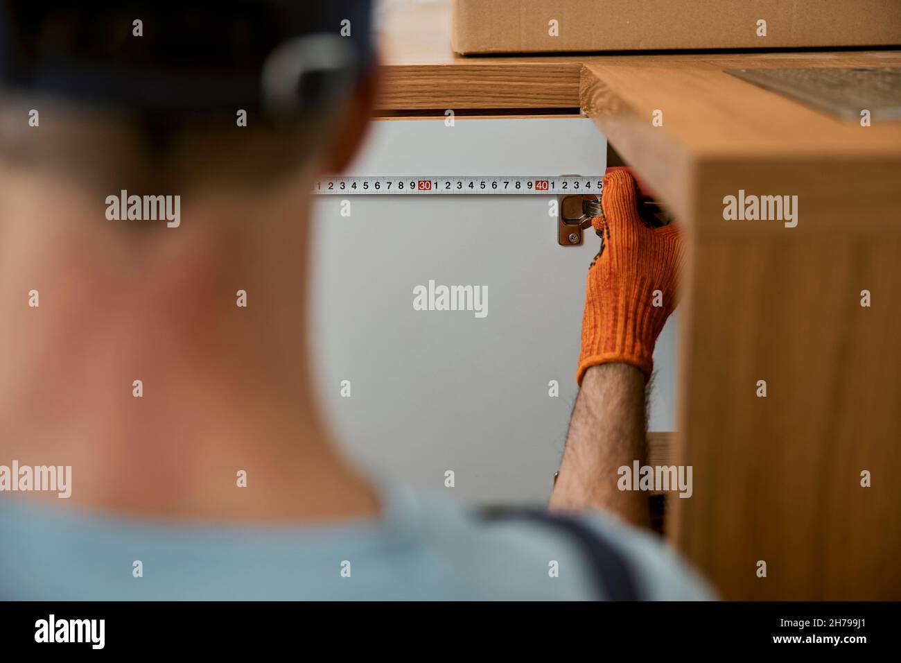 Male hand measuring cupboard door in kitchen Stock Photo - Alamy