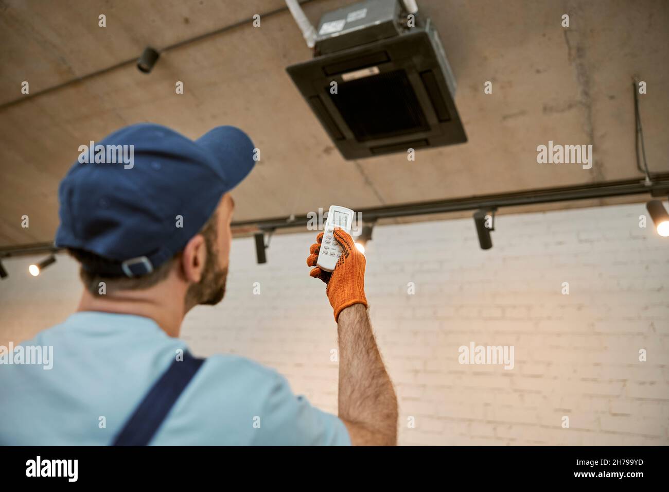 Male worker checking air conditioner in restaurant Stock Photo - Alamy