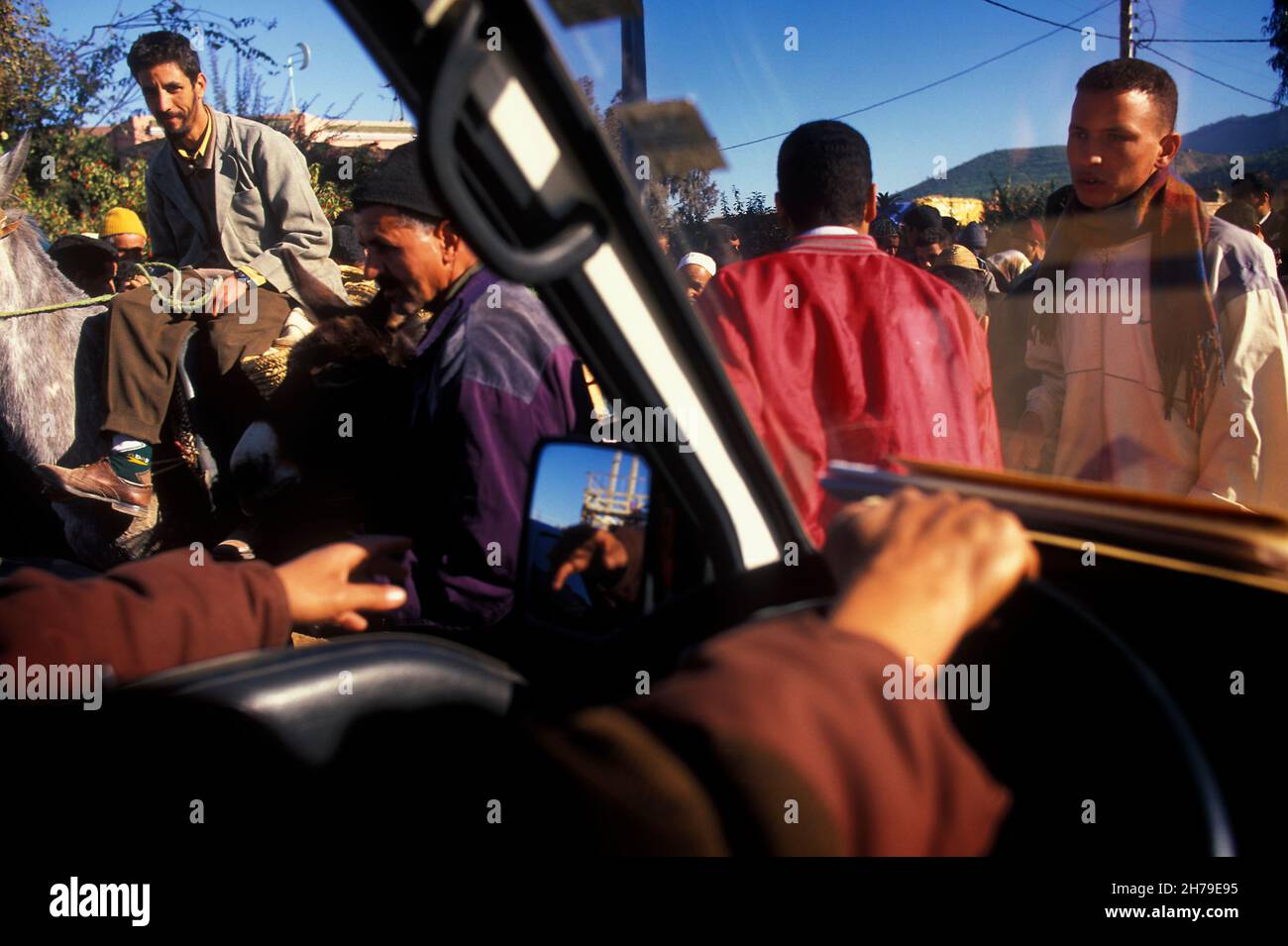 Driving slowly through a crowd of people during market day at Ourika ...