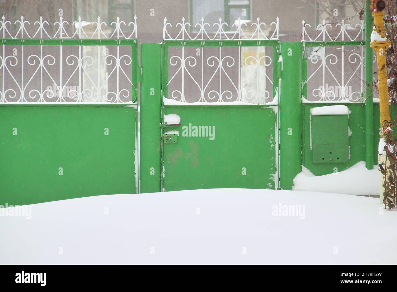 Snow covered gate in the poor village Stock Photo - Alamy