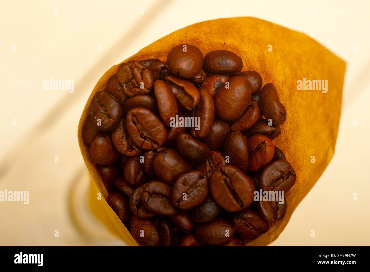 espresso coffee beans on a paper cone cornucopia over white background ...