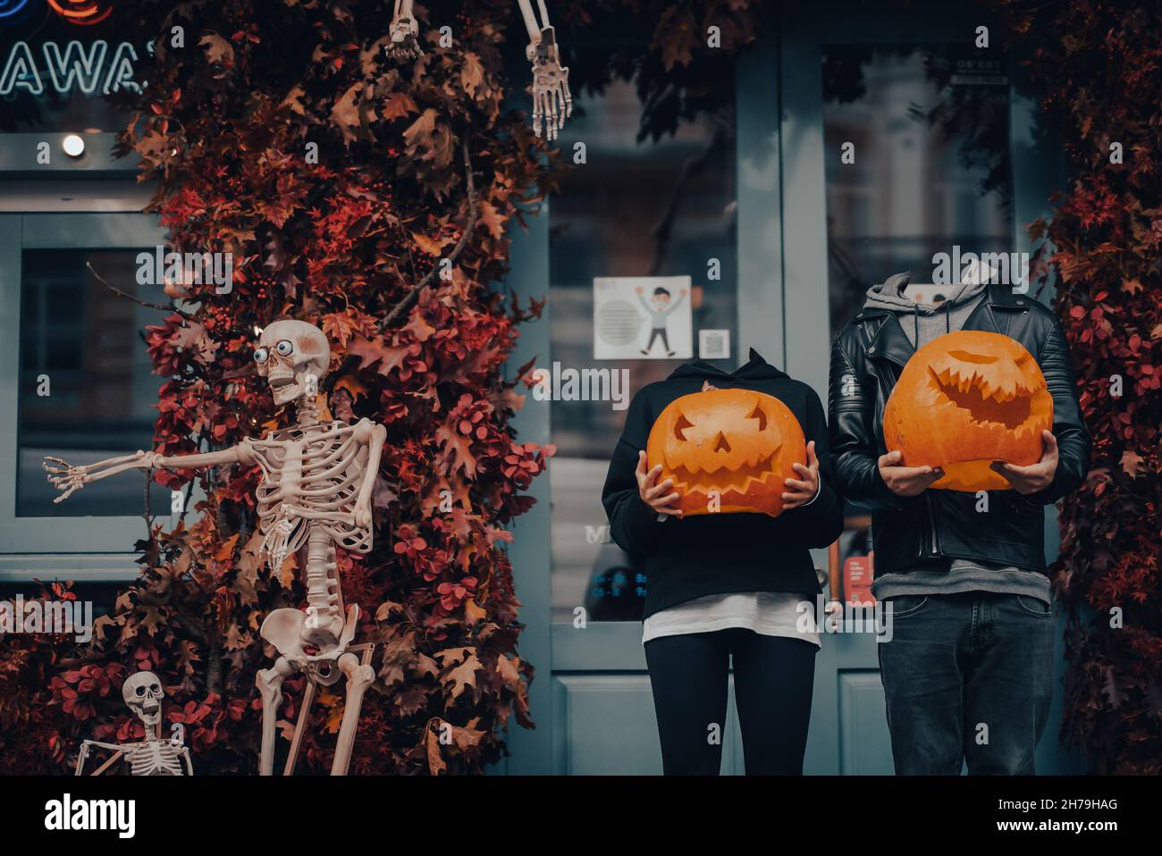 Headless couple holding pumpkin heads by the door on the street Stock ...