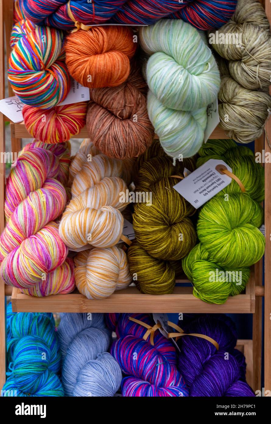 a selection of brightly coloured dyed skeins of wool on display at a ...