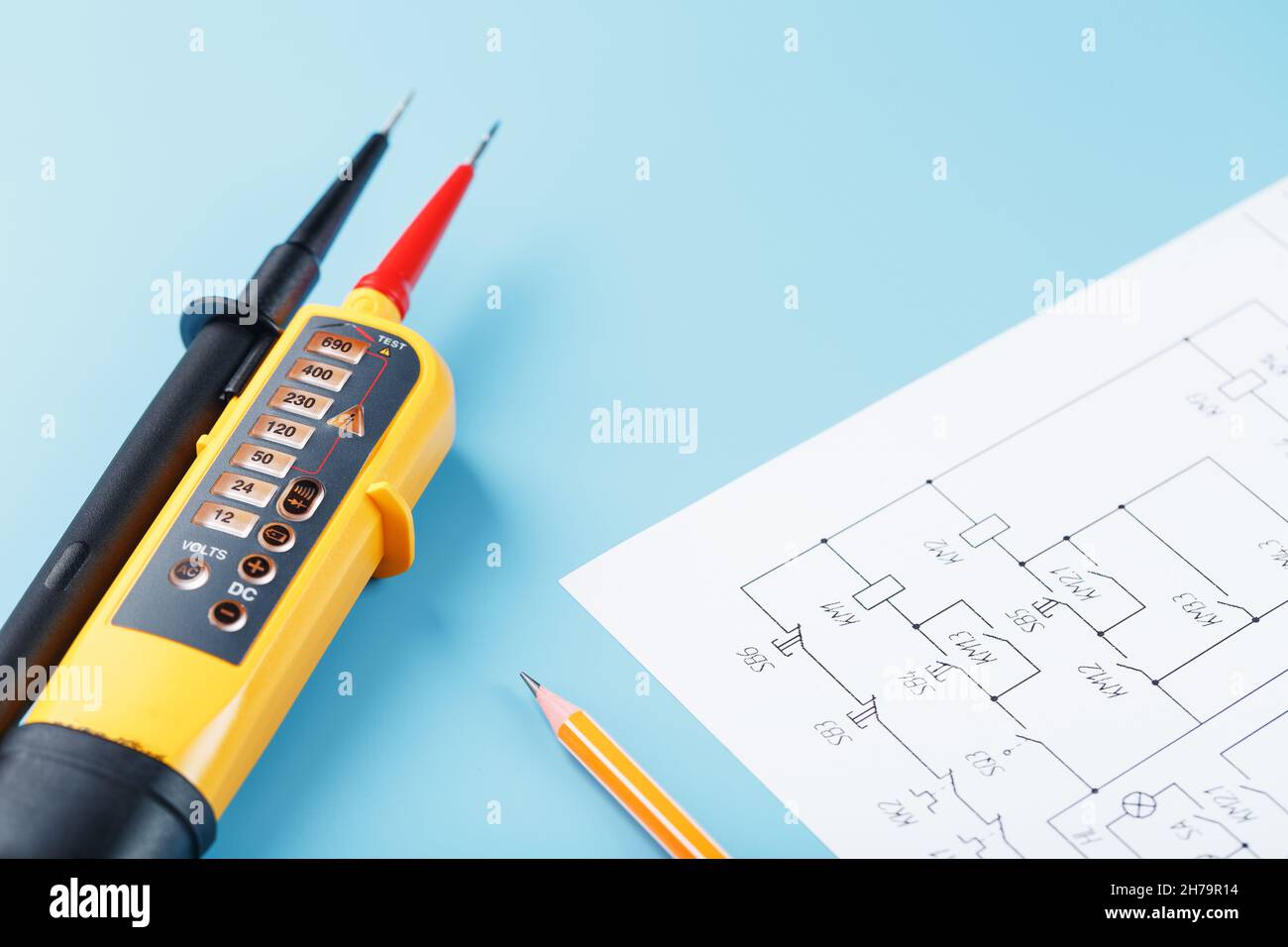 Two-pole voltage indicator with electrical drawings on a blue ...