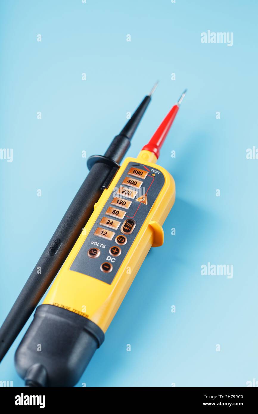 Two-pole voltage indicator close-up on a blue background. Testing and ...