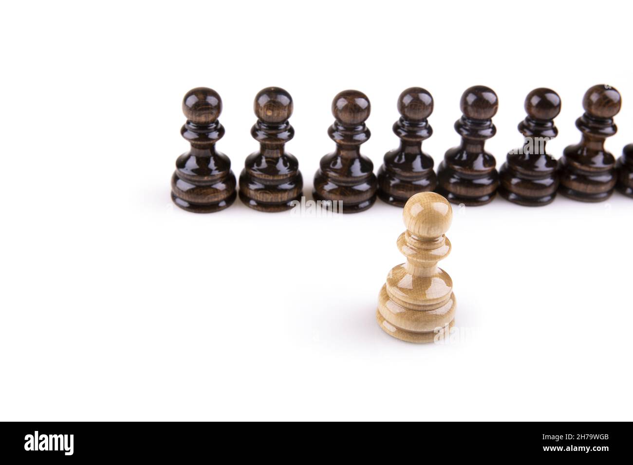 A single pawn against all black pawns isolated on white background ...