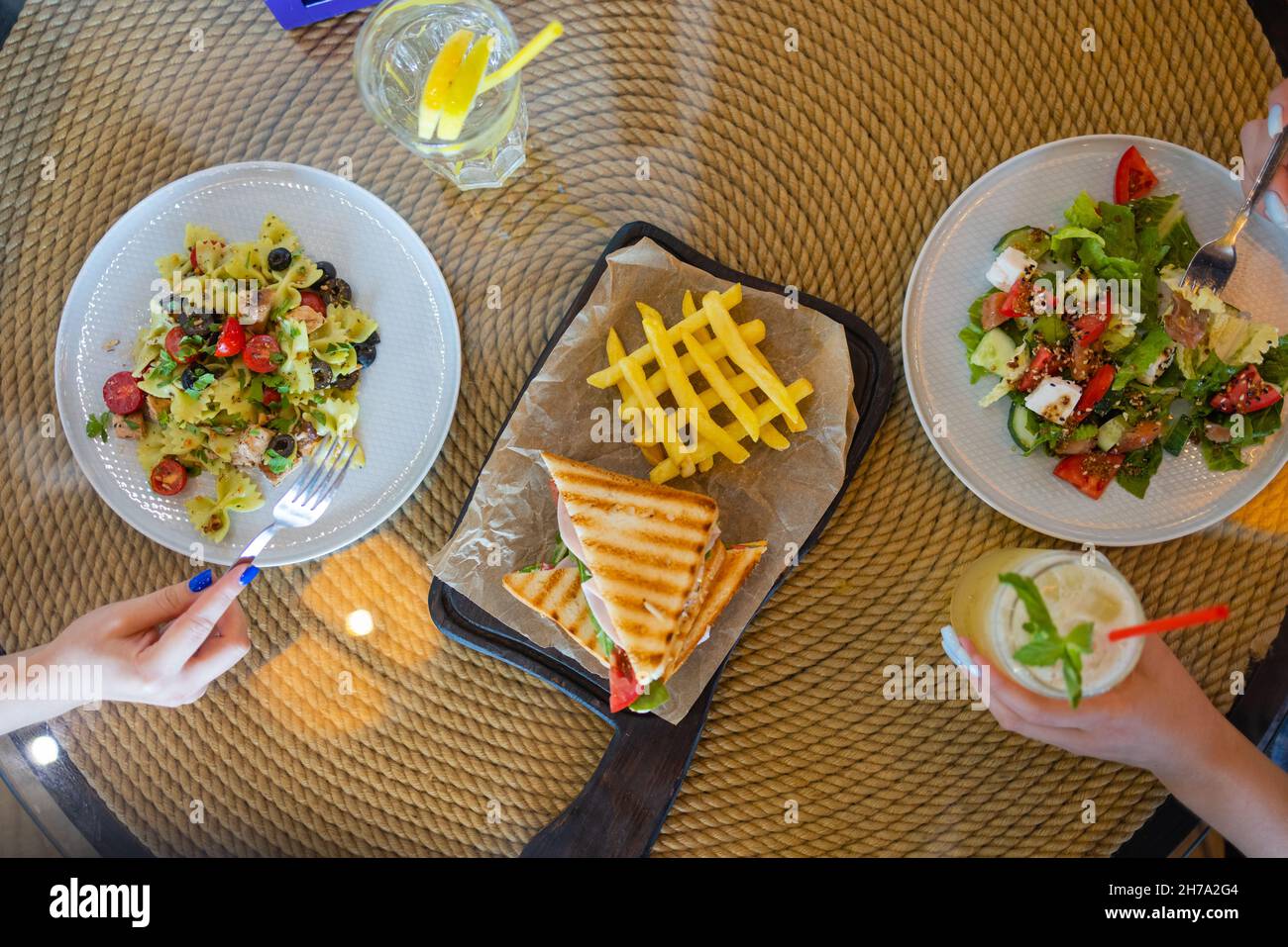 top view portrait of two young woman having lunch together at cafe ...