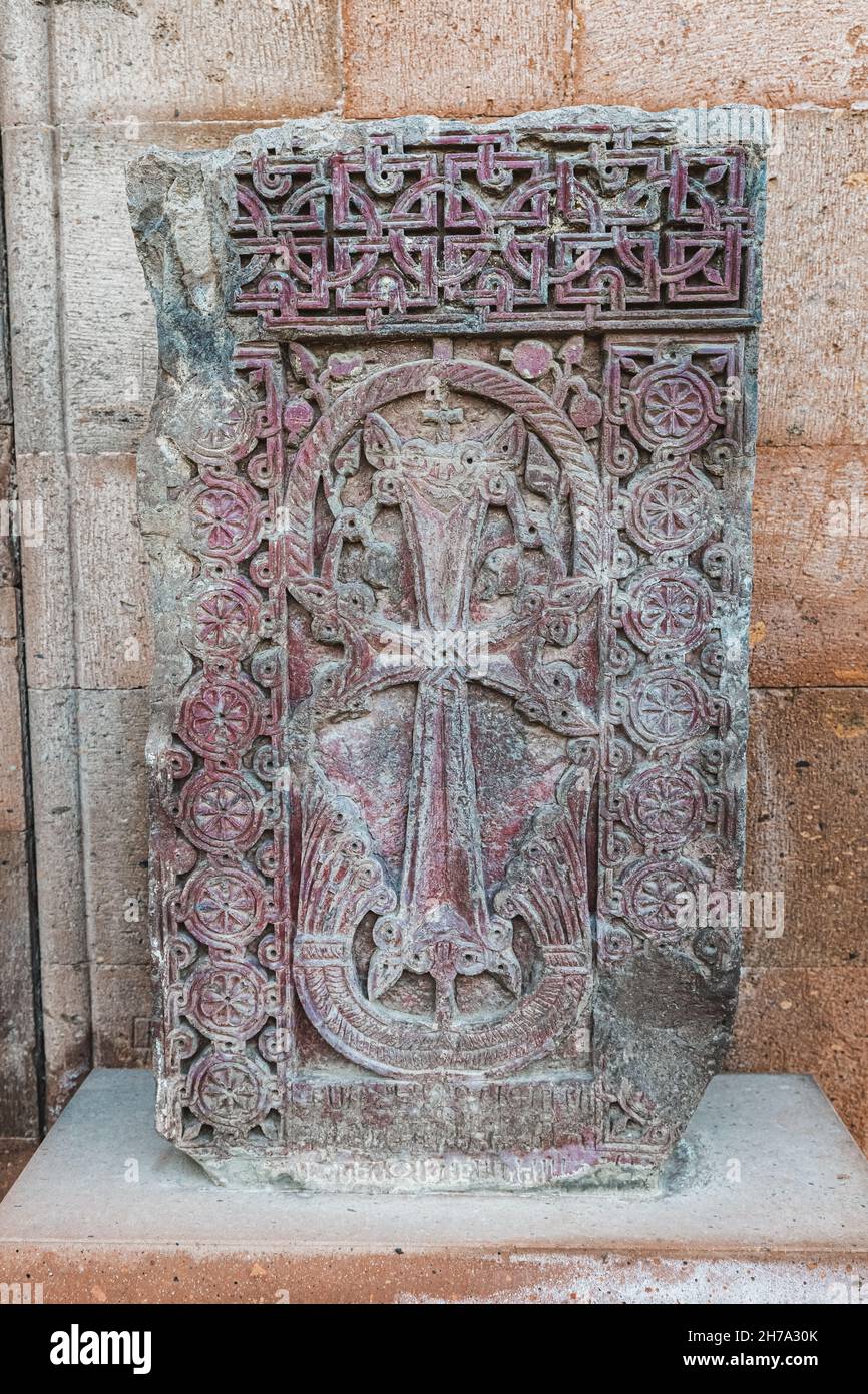 A traditional carved khachkar made of pink stone installed near St ...