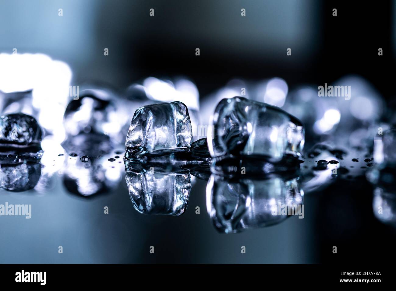 pile of different ice cubes on reflection table on black background ...