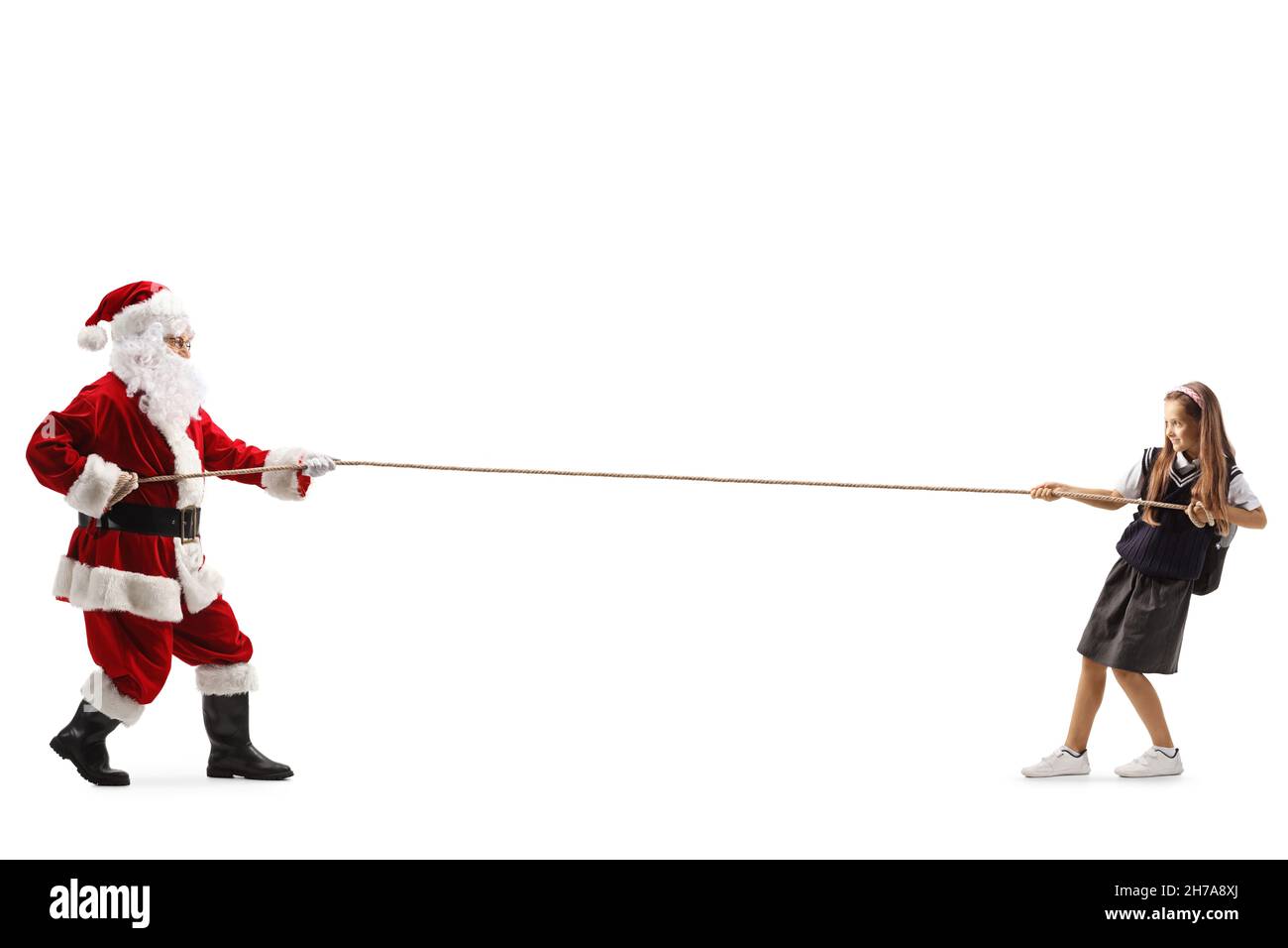 Full length profile shot of a schoolgirl and santa claus pulling a rope ...
