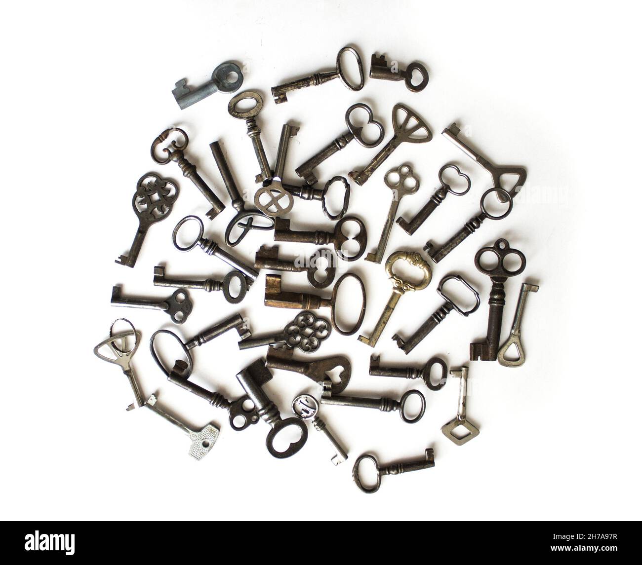 A pile of different metal keys on a white background Stock Photo - Alamy