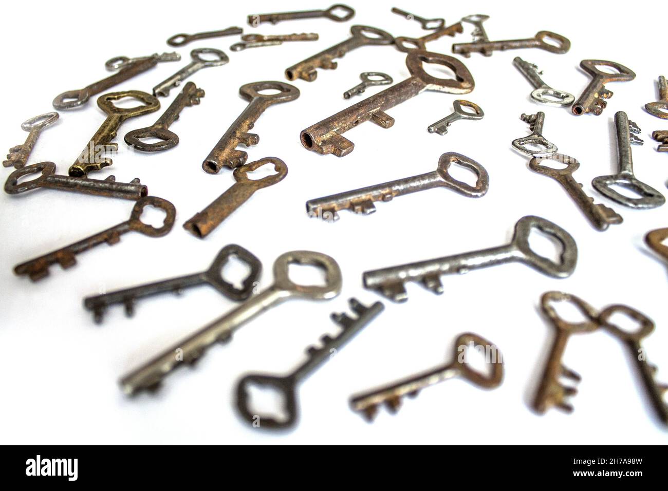 A pile of different metal keys on a white background Stock Photo - Alamy
