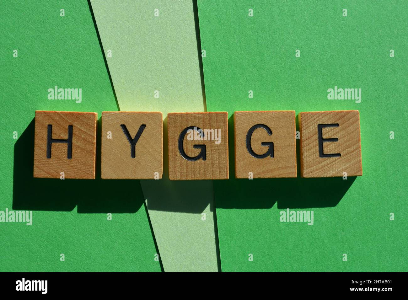 Hygge, word in wooden alphabet letters isolated on green background as ...