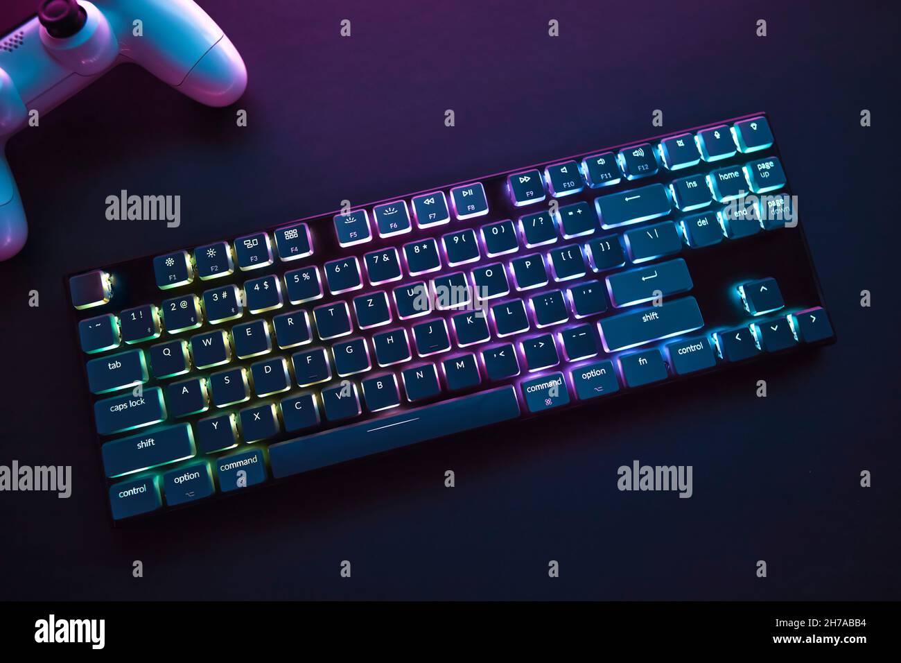 Top down view of color backlighted gaming accessories laying on dark ...