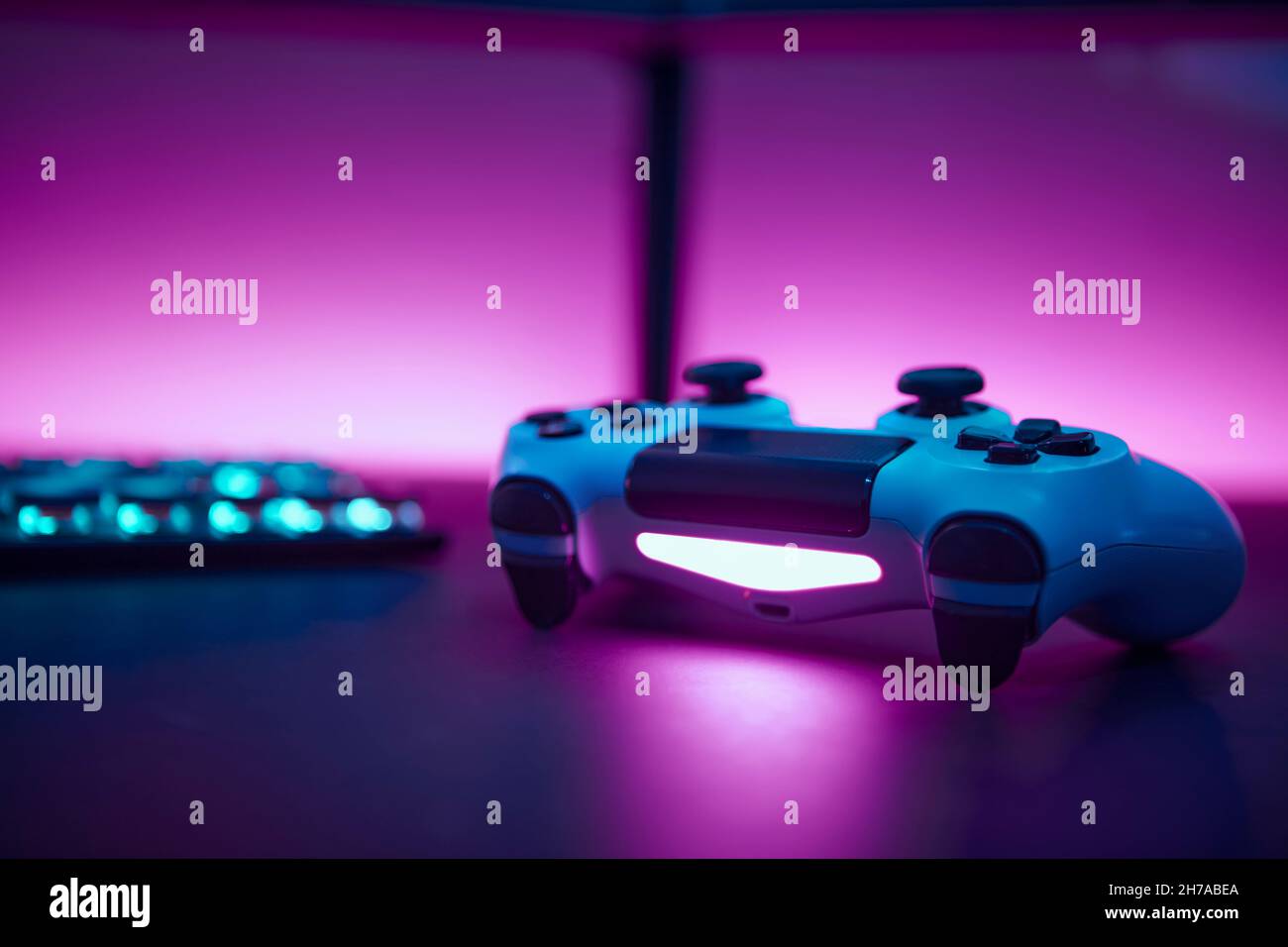 Low angle view game controller on table. Blank dual display and pink ...