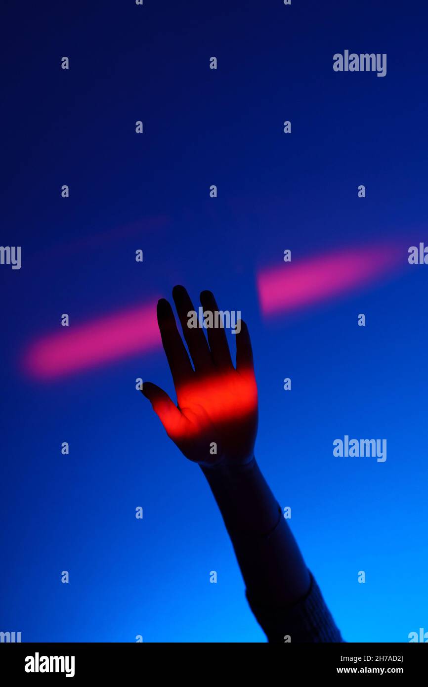 Woman arm gesturing with open hand over fashion blue background, neon ...