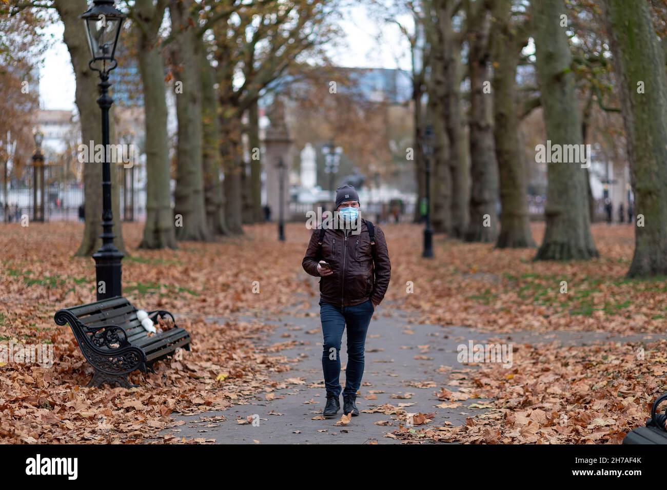 London, UK. 21st Nov, 2021. A man wearing a facemask is seen walking ...