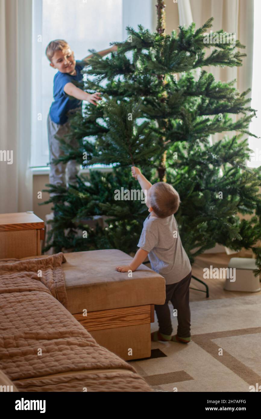 Children assemble an artificial Christmas tree from branches in their ...