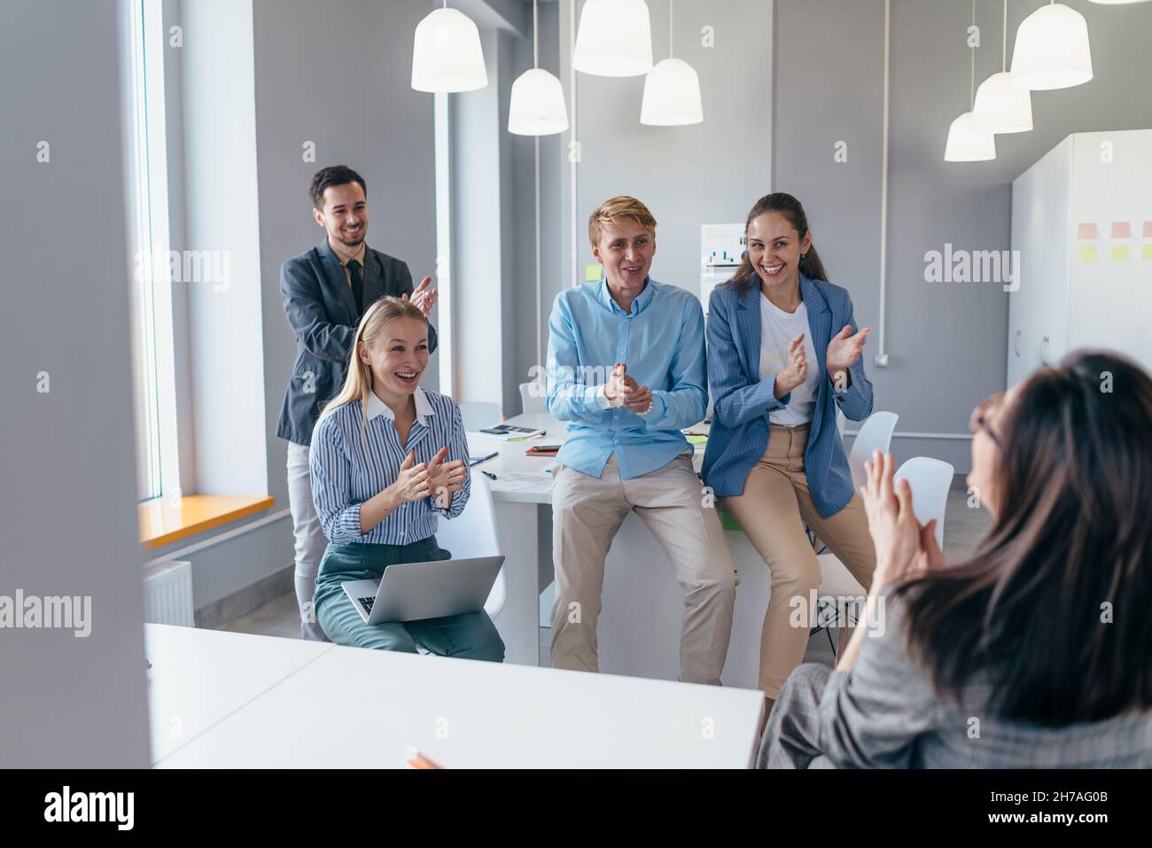Businessoman receives approval and applause from her colleagues in an ...
