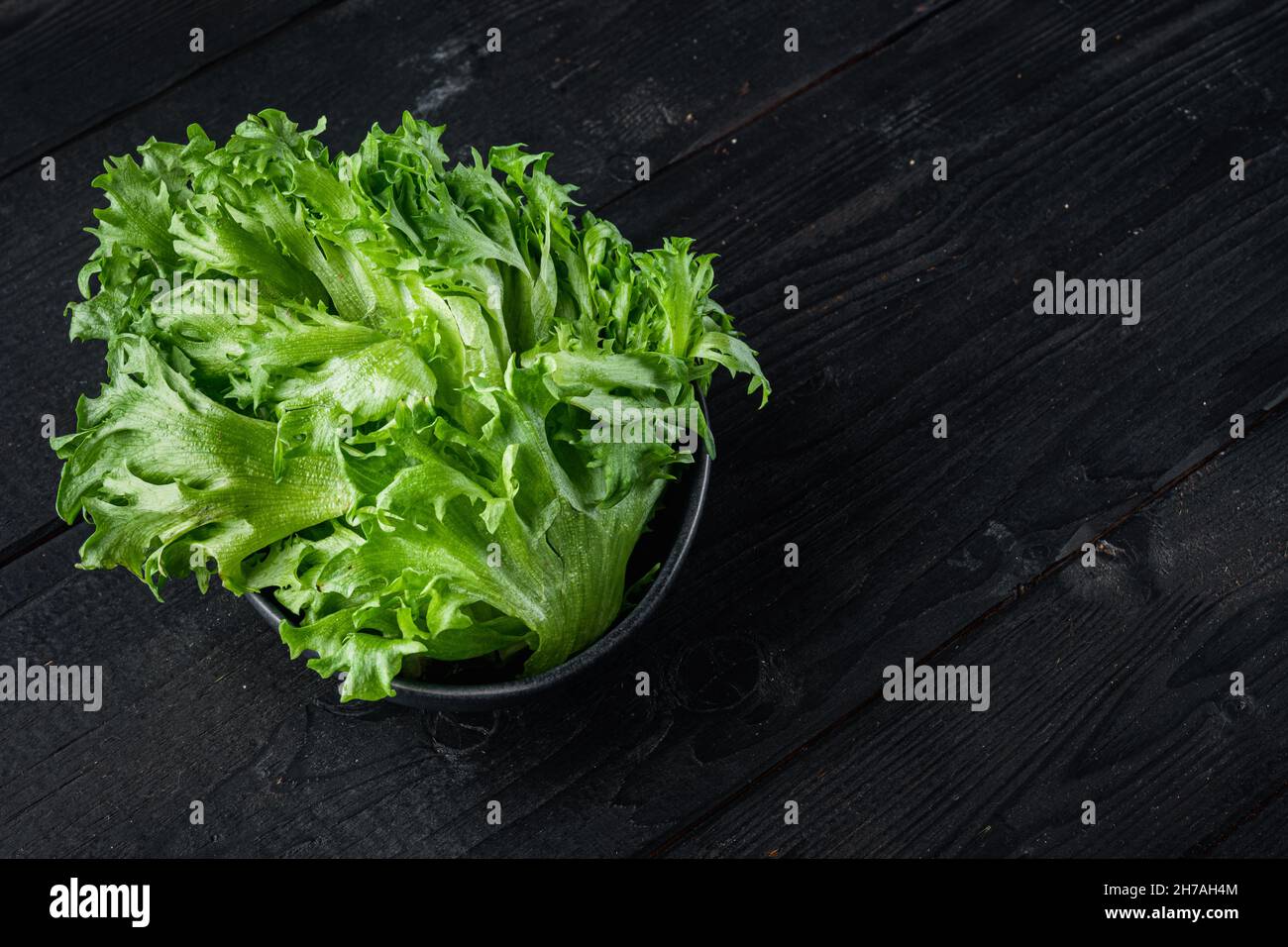 Fresh organic green batavia lettuce leaves, on black wooden table ...