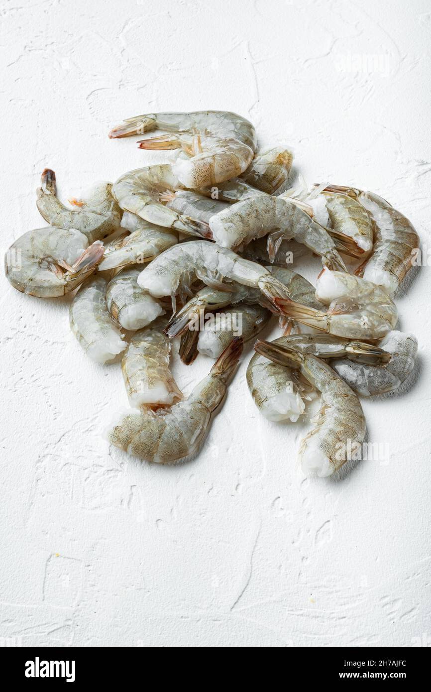 Raw shell on king prawns set, on white stone surface, with copy space ...