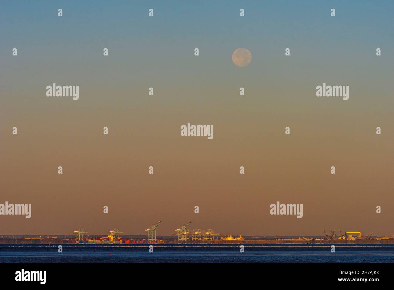 A nearly full moon sets above a port in Mobile, Alabama Stock Photo - Alamy