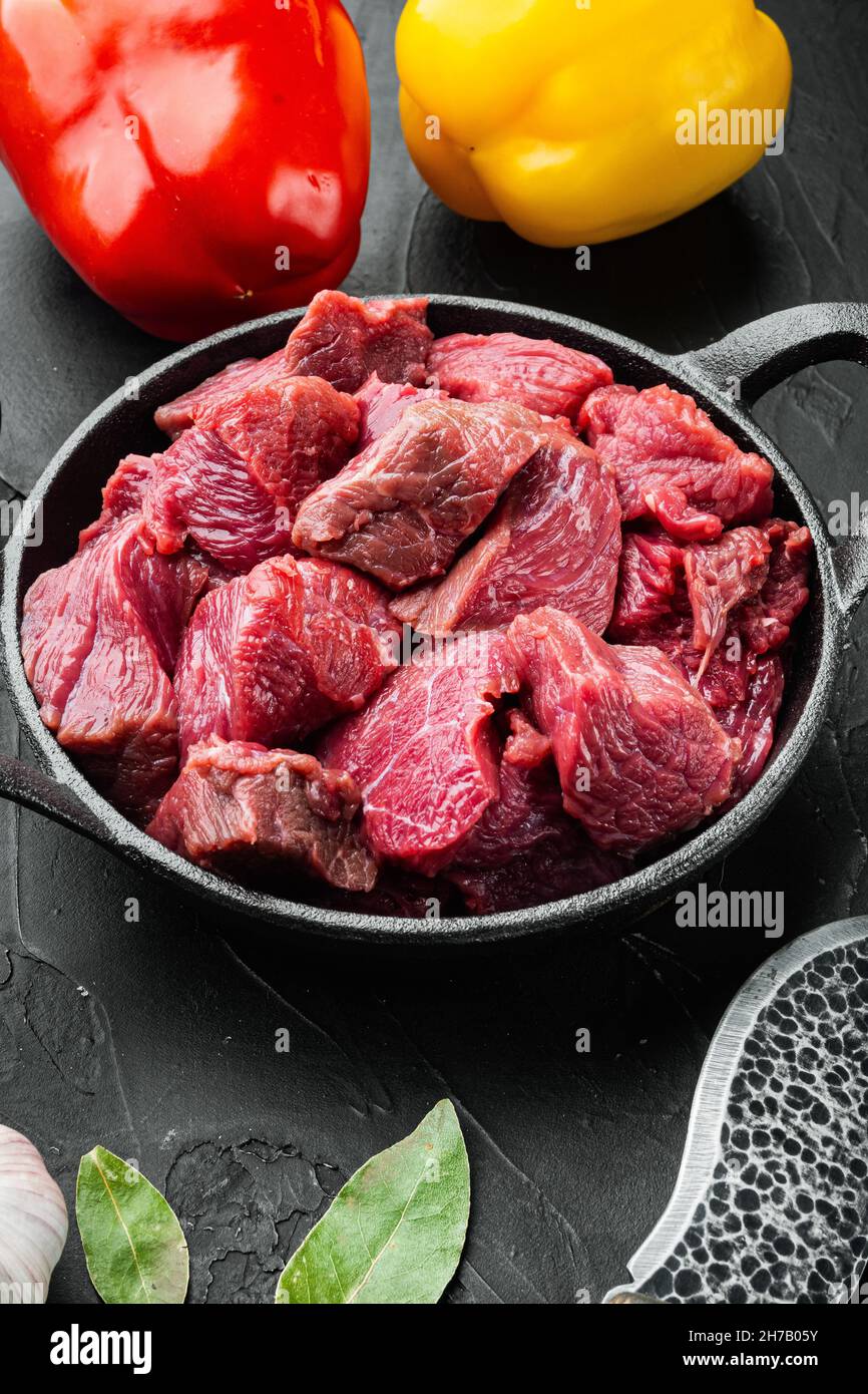 Raw lean stewing beef set with sweet bell pepper, in cast iron frying ...