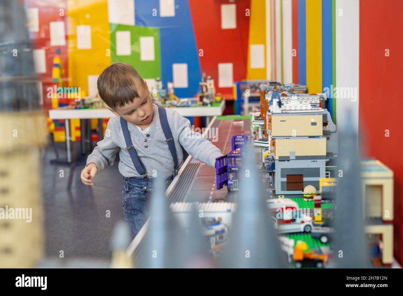 Little boy plays color Lego set on the table. Early training and ...