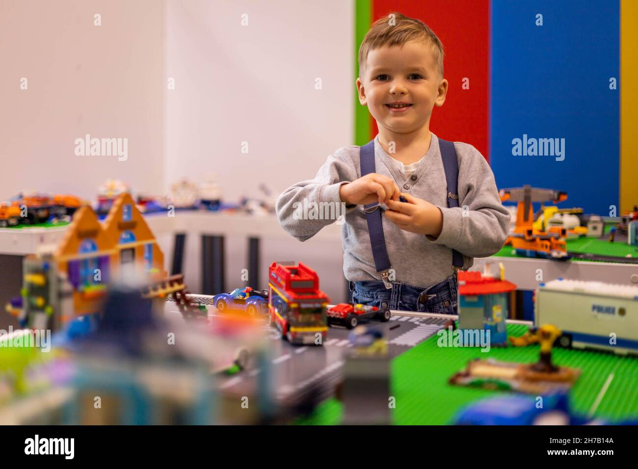 Little boy plays color Lego set on the table. Early training and ...