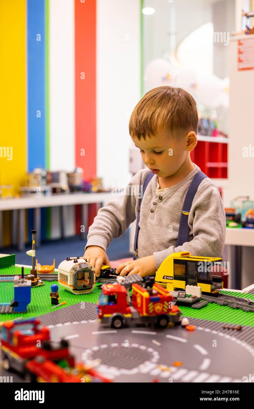 Little boy plays color Lego set on the table. Early training and ...