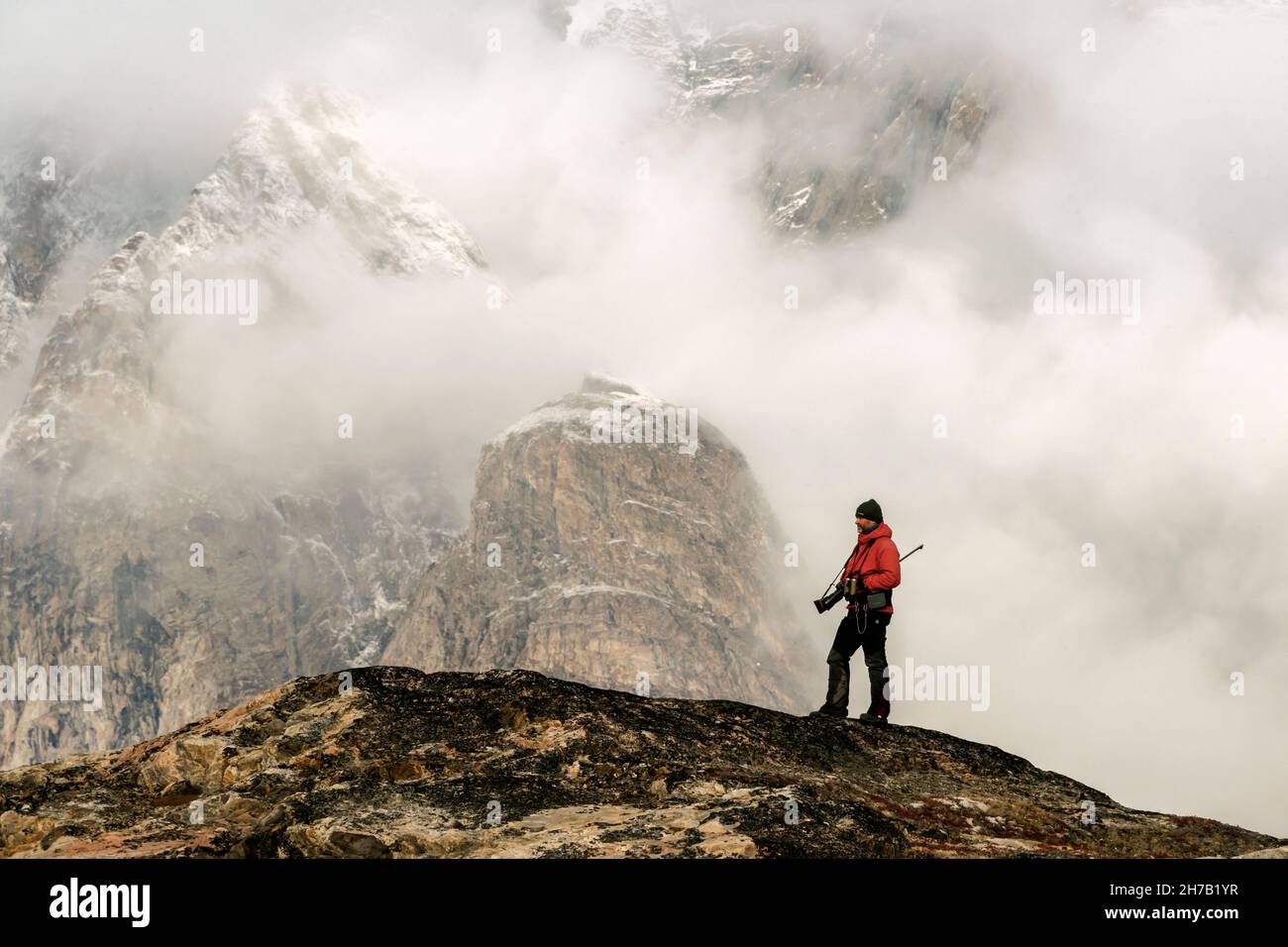 Guide with rifle, misty mountains, NE Milne Land, Scoresby Sund ...