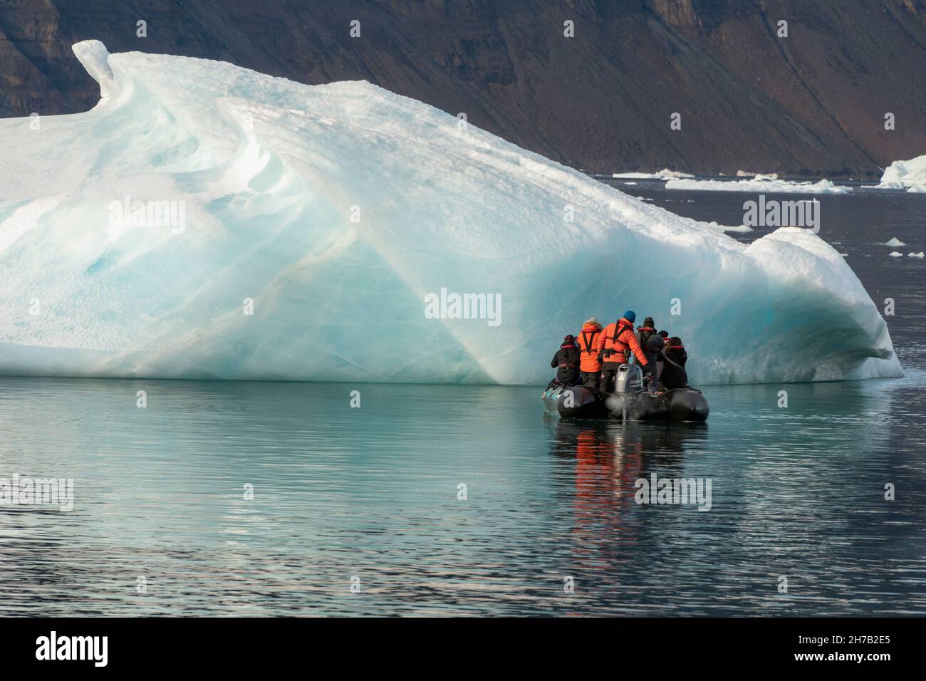 Photographers head to a small blue iceberg, Vikingebugt Inlet, Scoresby ...