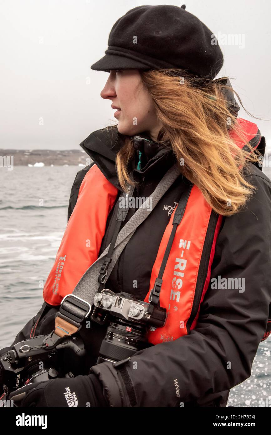 Woman photographing icebergs from a zodiak off Denmark Island, Scoresby ...
