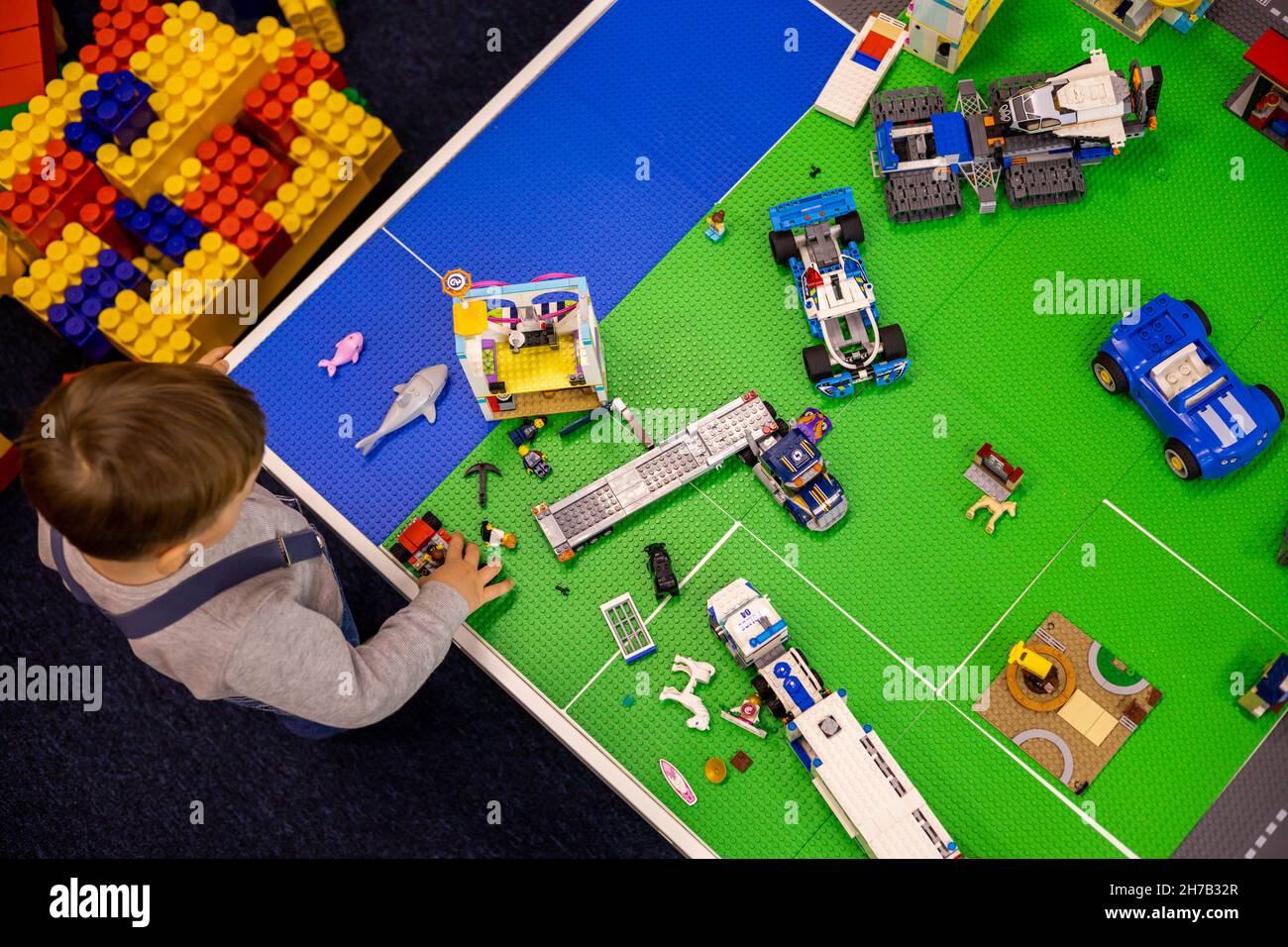 Little boy plays color Lego set on the table. Early training and ...